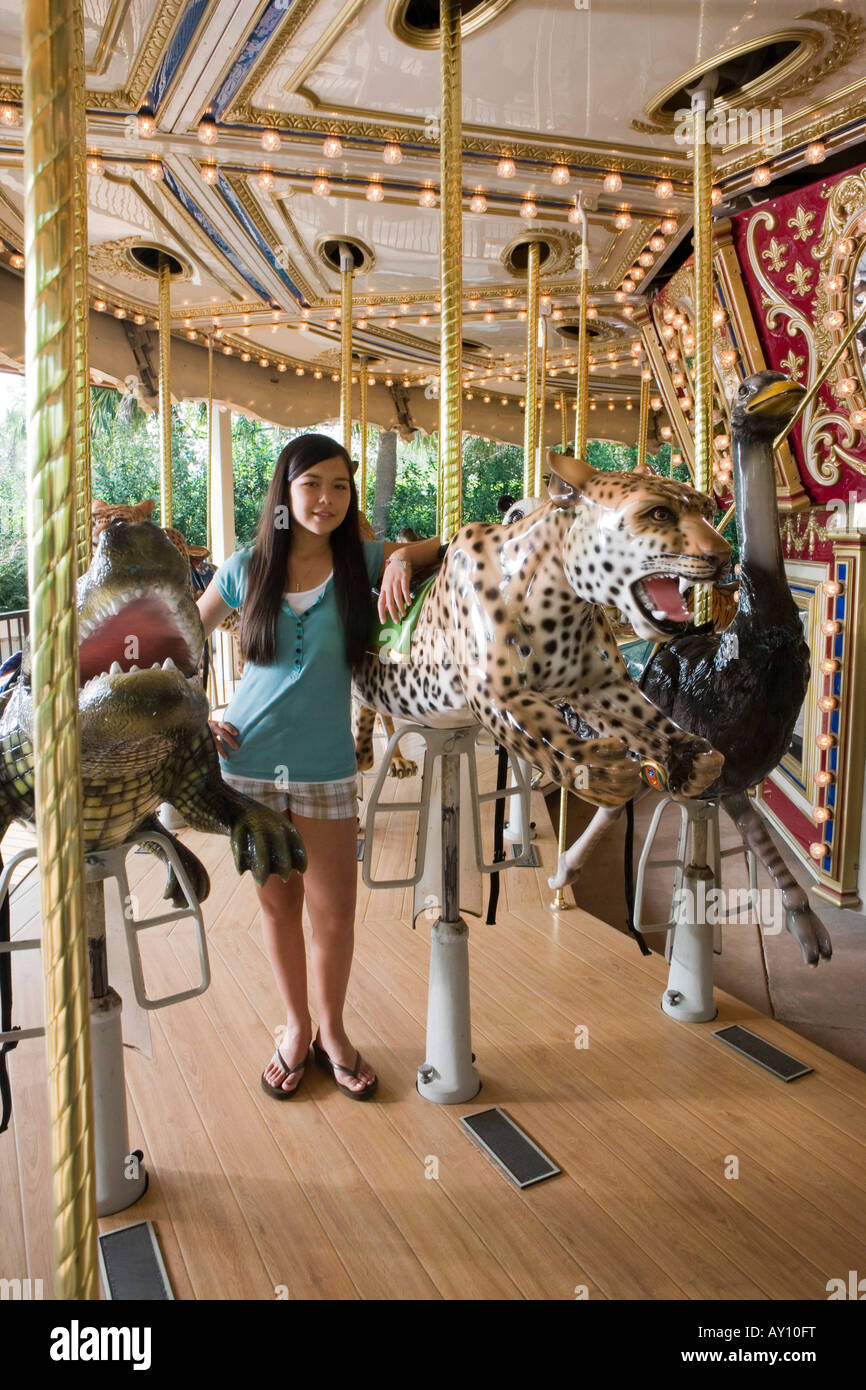 Portrait of a cheerful girl standing in a carousel by a carousel ...