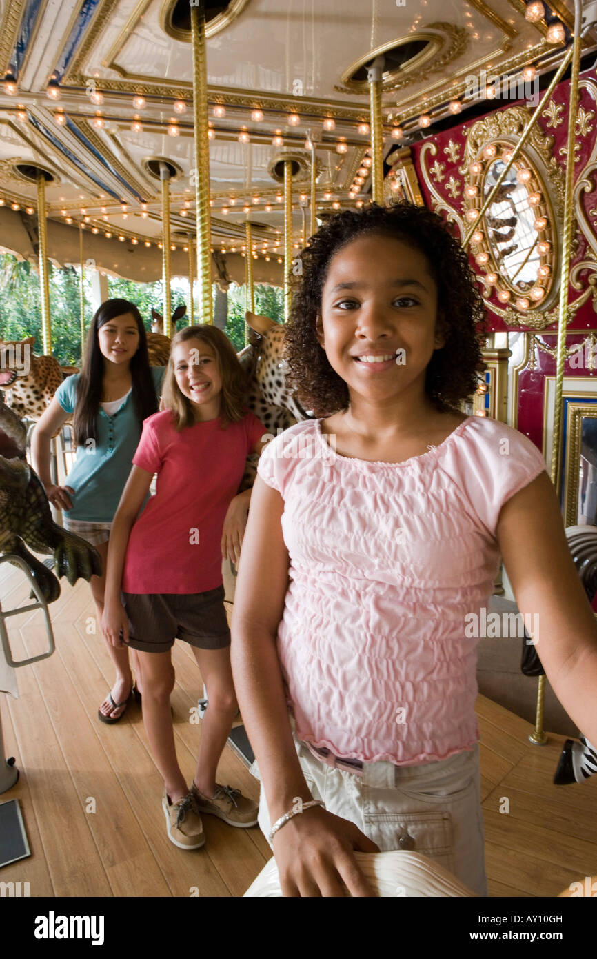Portrait of cheerful teenage girls standing in a carousel by a carousel ...