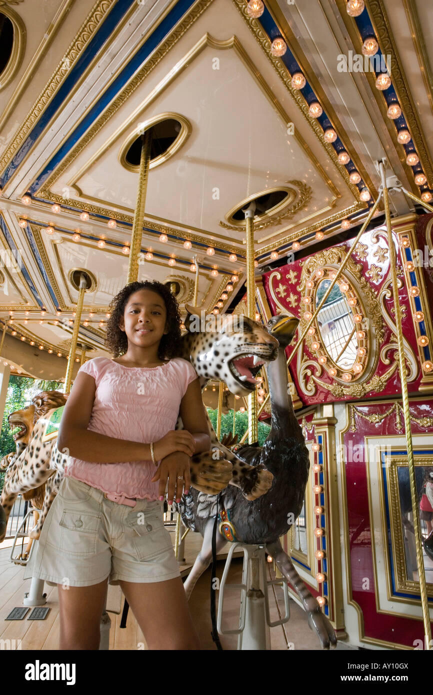 Portrait of a cheerful girl standing in a carousel by a carousel ...