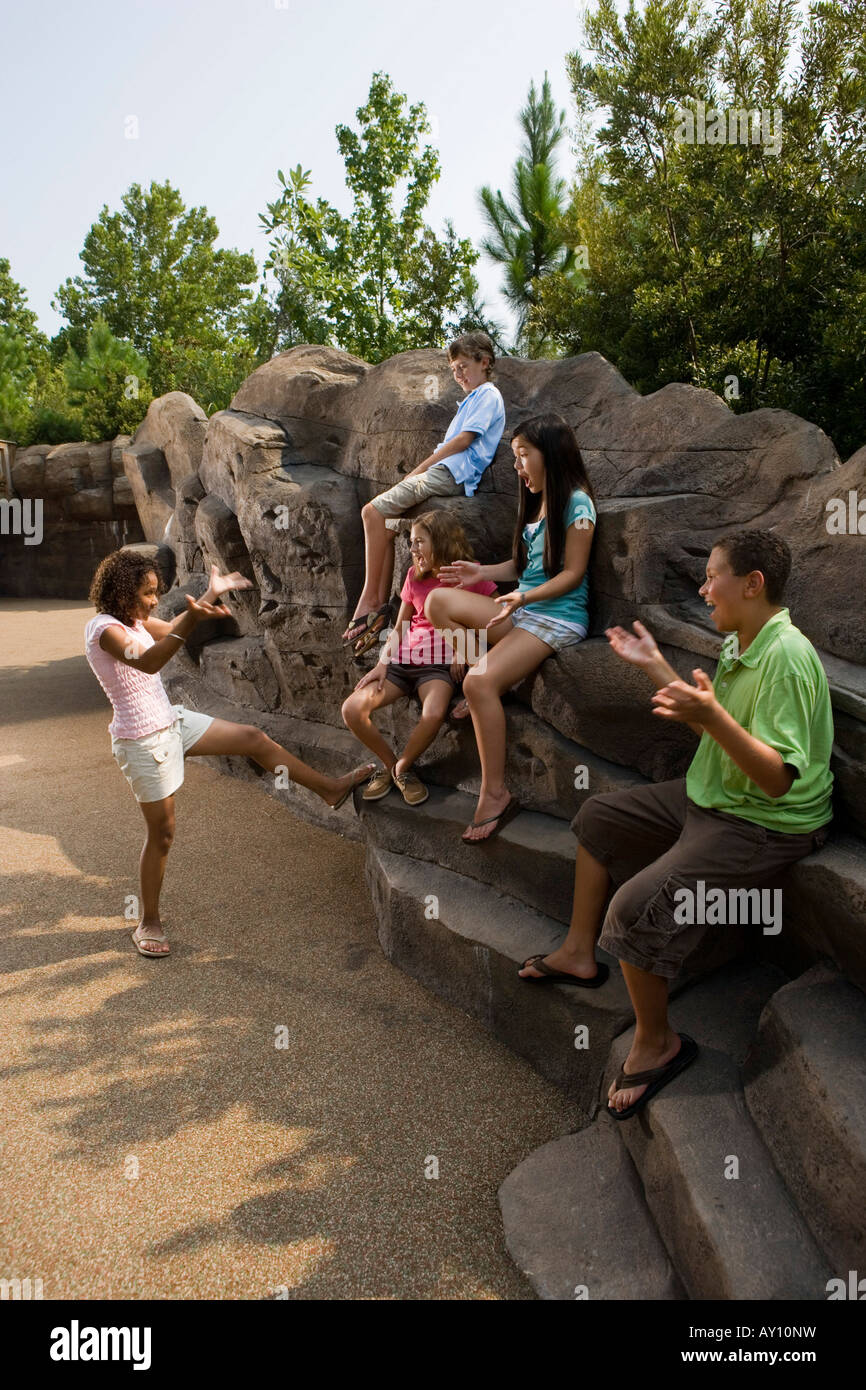 Teenagers sitting on rocks and playing Stock Photo - Alamy