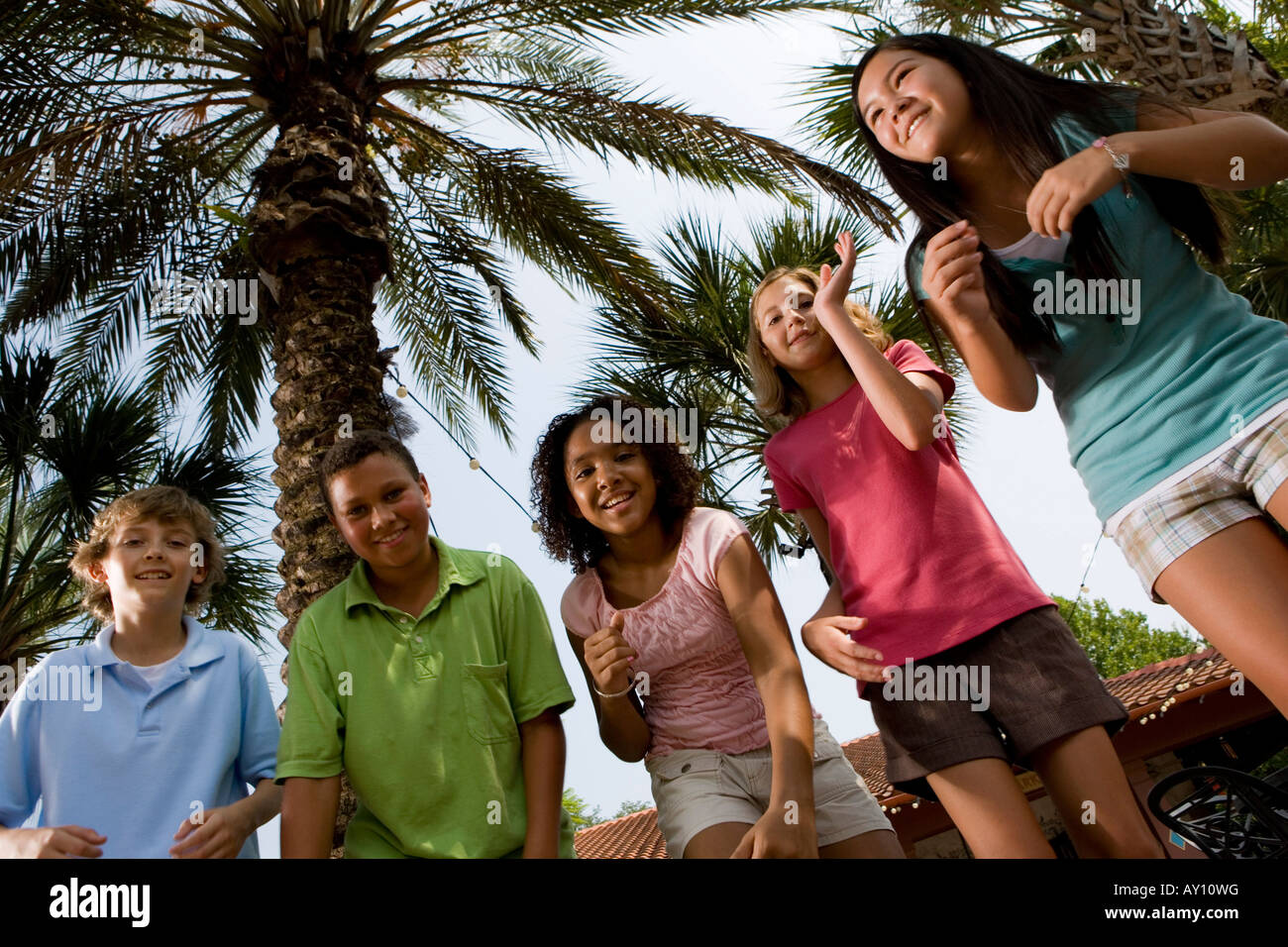 Portrait of teenagers dancing under a palm tree Stock Photo - Alamy