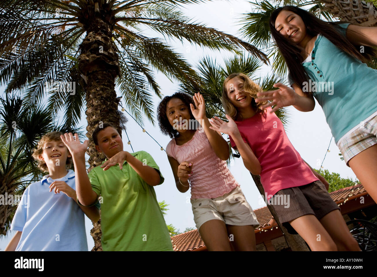 Portrait of teenagers dancing under a palm tree Stock Photo - Alamy