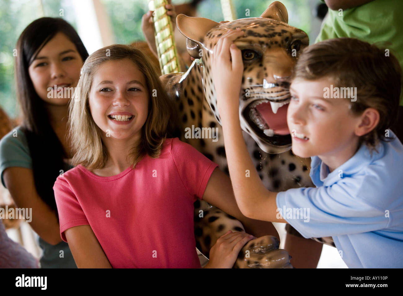 Teenagers holding a carousel leopard and smiling Stock Photo - Alamy
