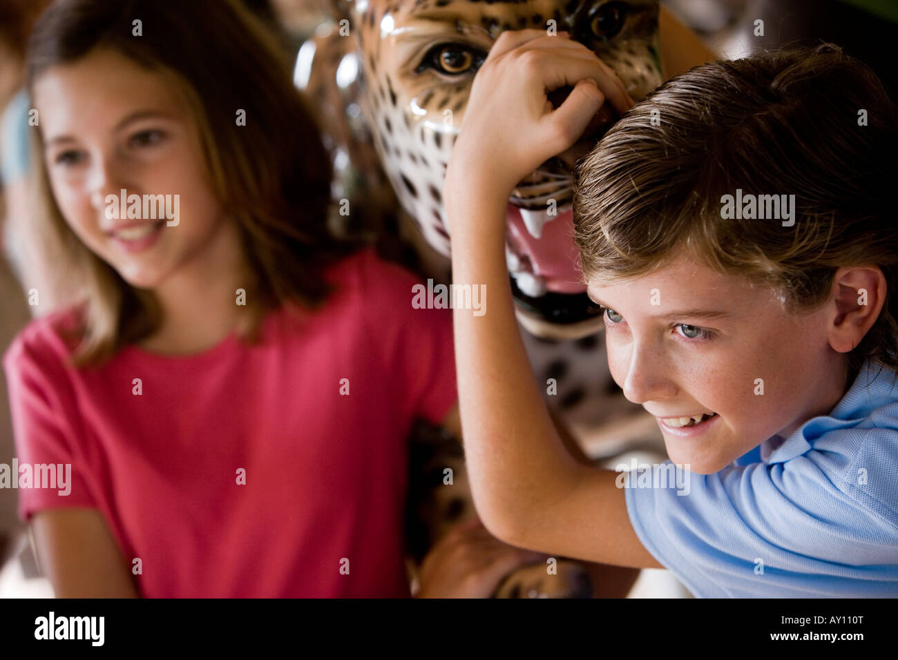 Teenagers holding a carousel leopard and smiling Stock Photo - Alamy