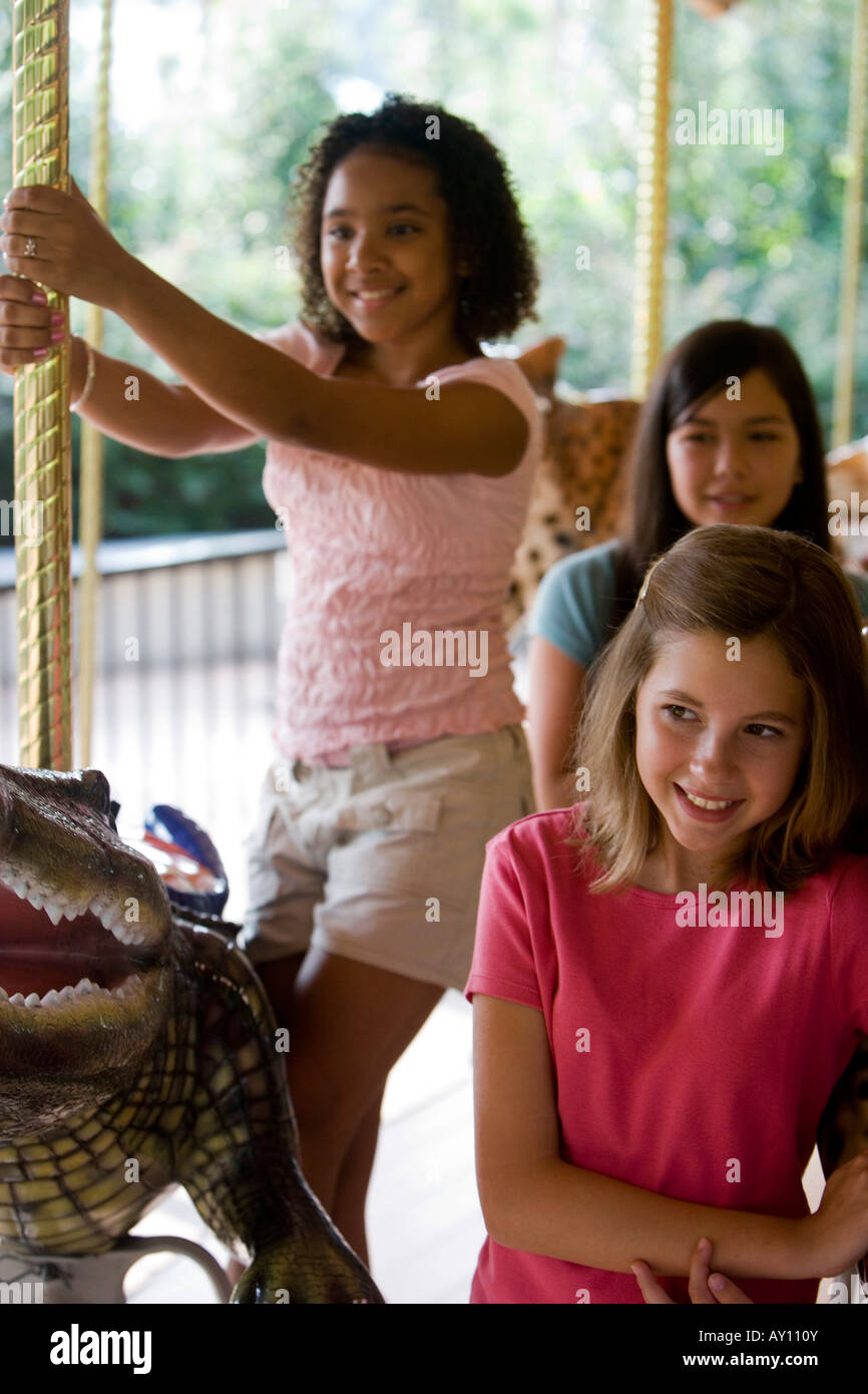 Cheerful teenage girls standing on a carousel Stock Photo - Alamy