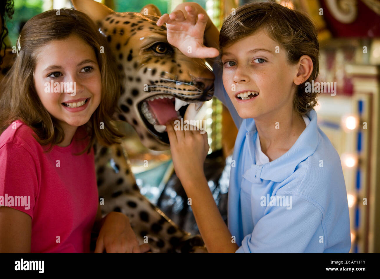Teenagers holding a carousel leopard and smiling Stock Photo - Alamy