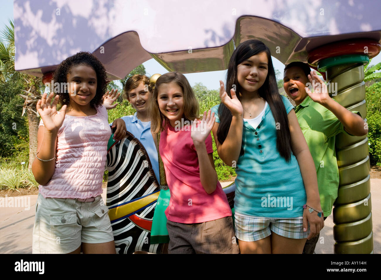 Portrait of cheerful teenagers standing together and waving hands Stock ...