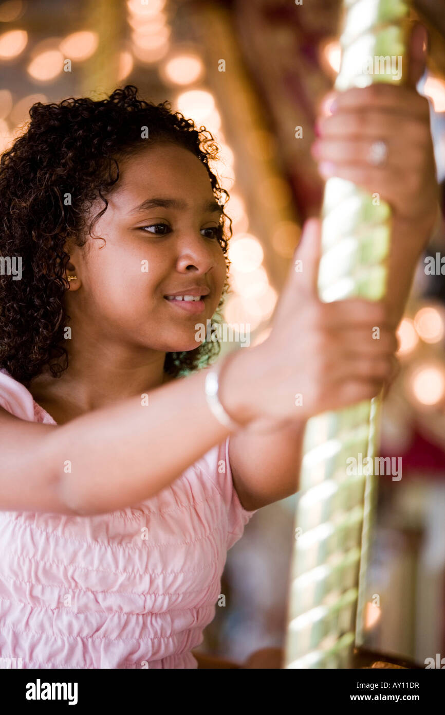 Teenage girl holding a pole in a carousel Stock Photo - Alamy