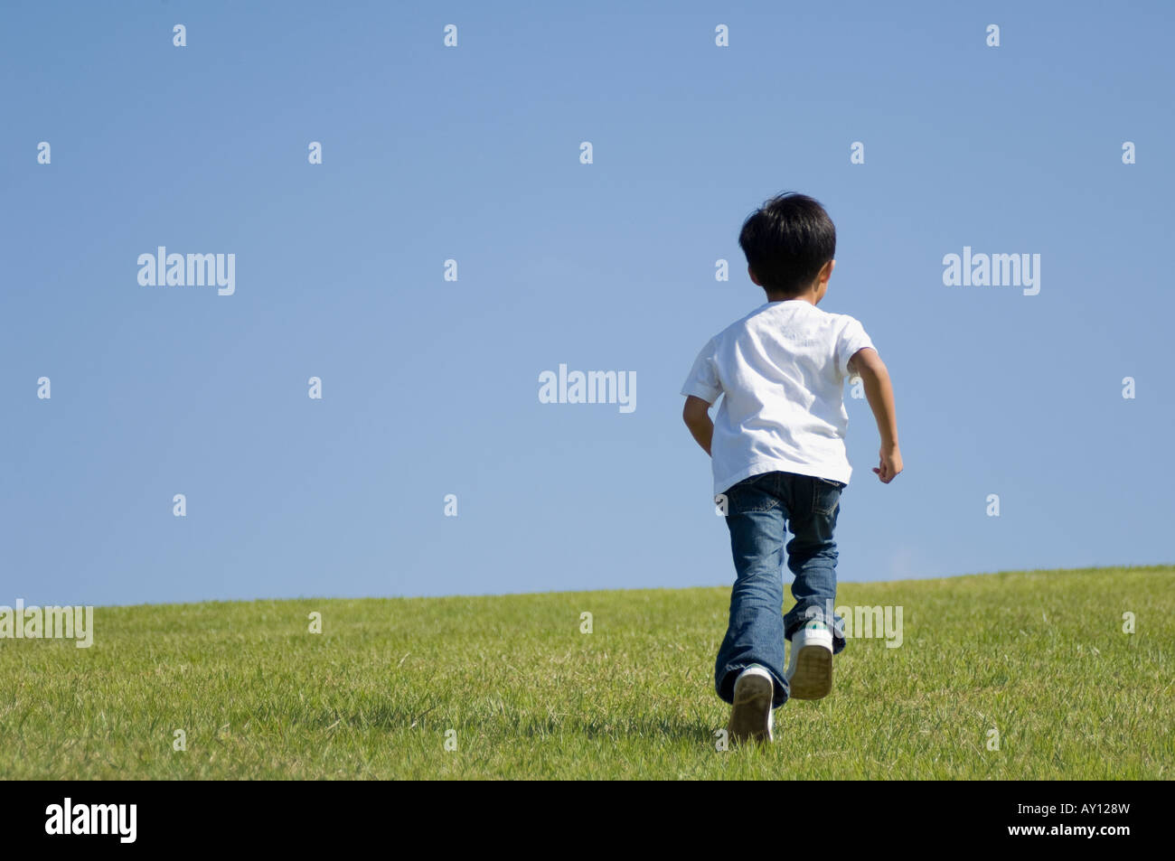 Boy running in field Stock Photo - Alamy
