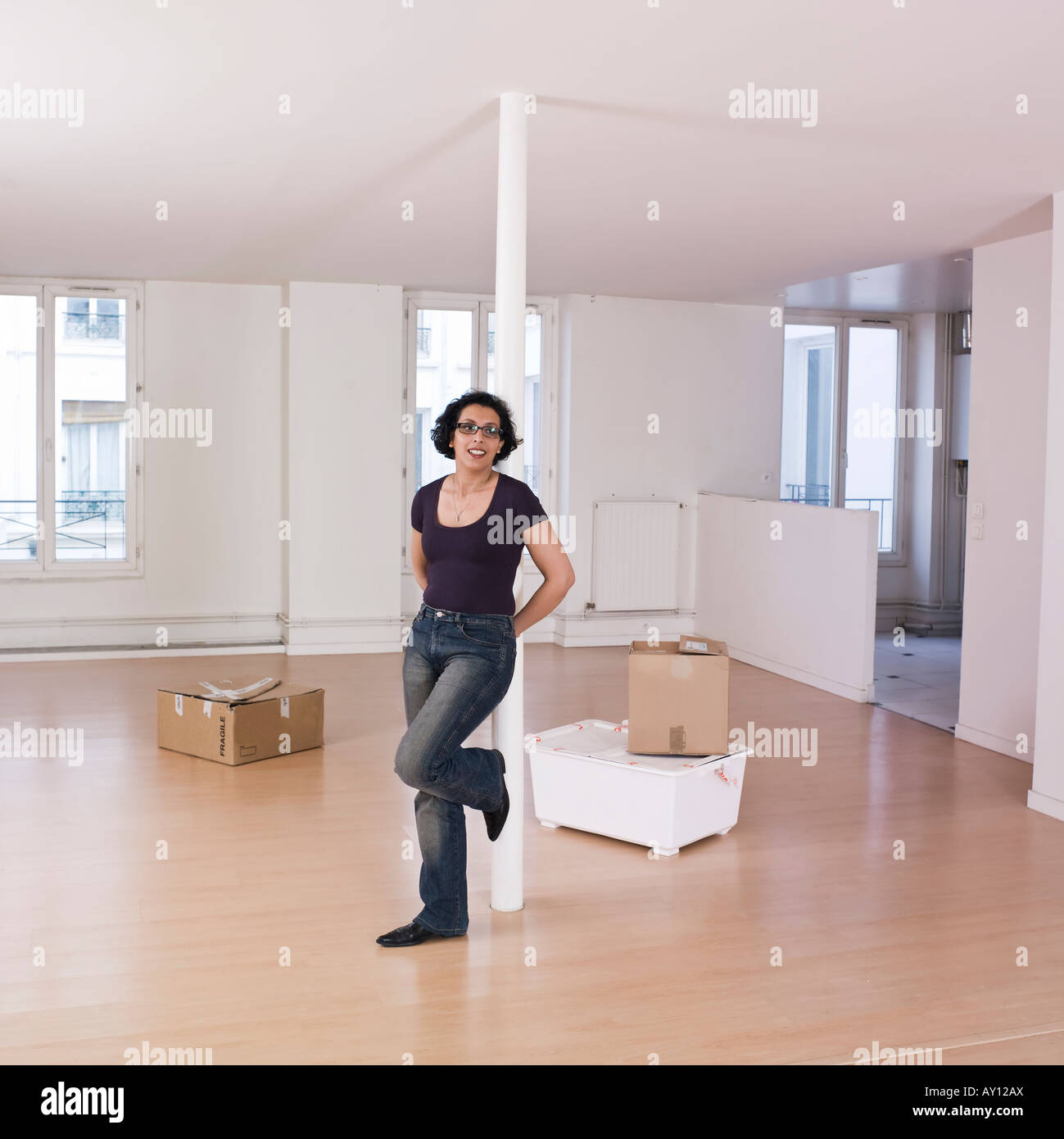 woman alone smiling inside an empty loft appartement Stock Photo - Alamy