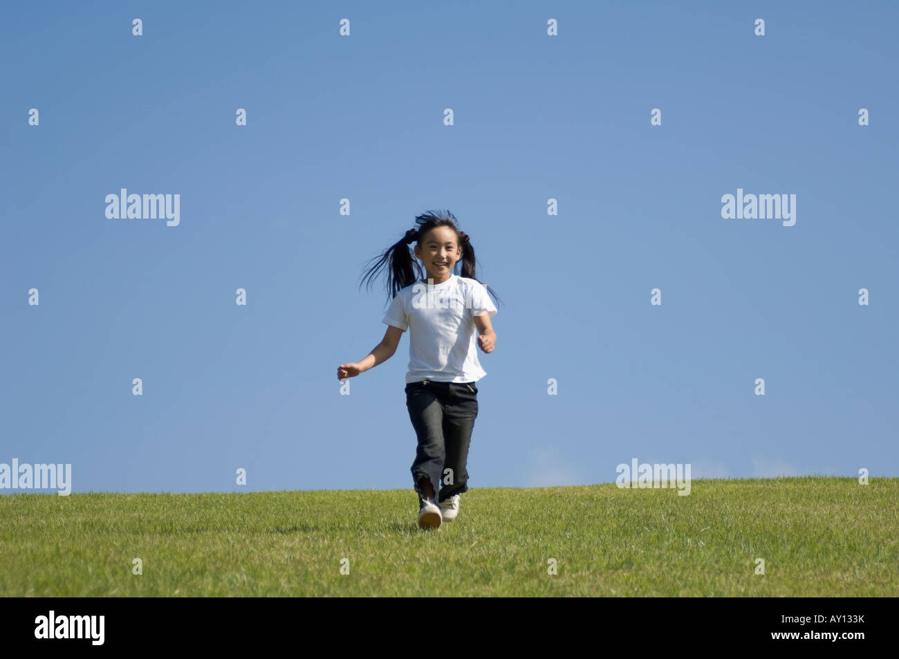 Girl running in field Stock Photo - Alamy