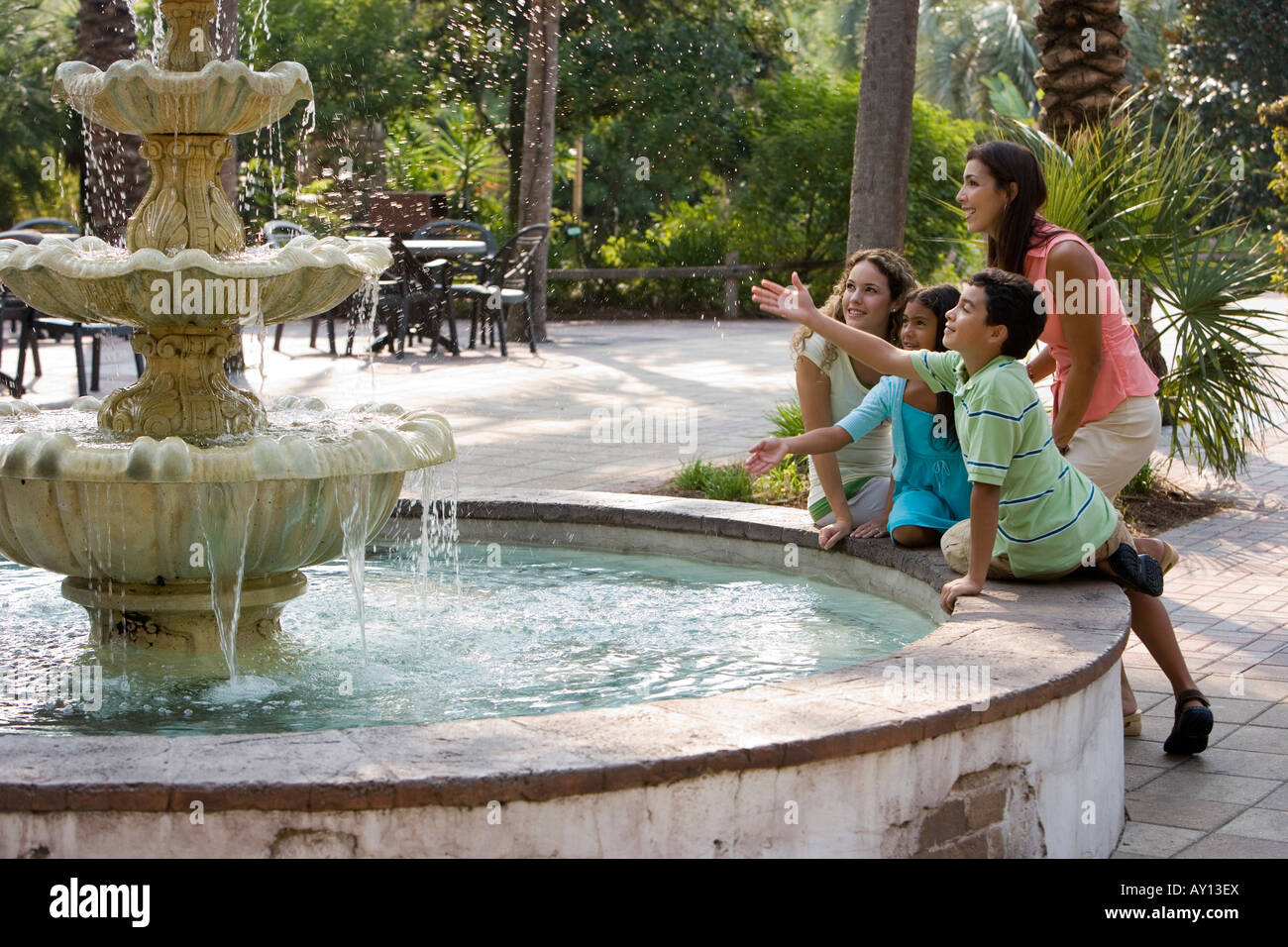 People sitting together by a water fountain Stock Photo - Alamy