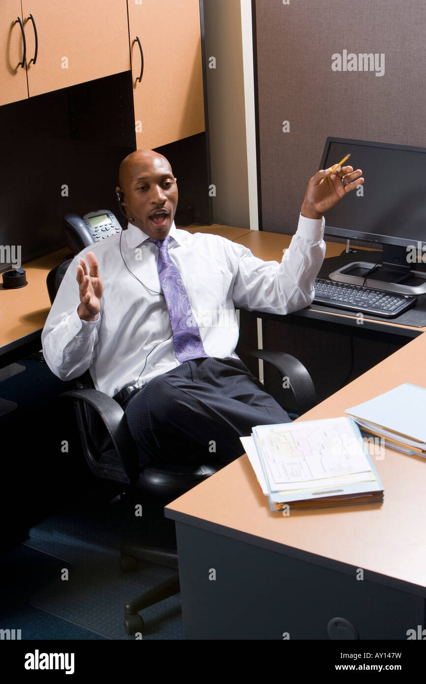 Businessman sitting by a computer in an office Stock Photo - Alamy