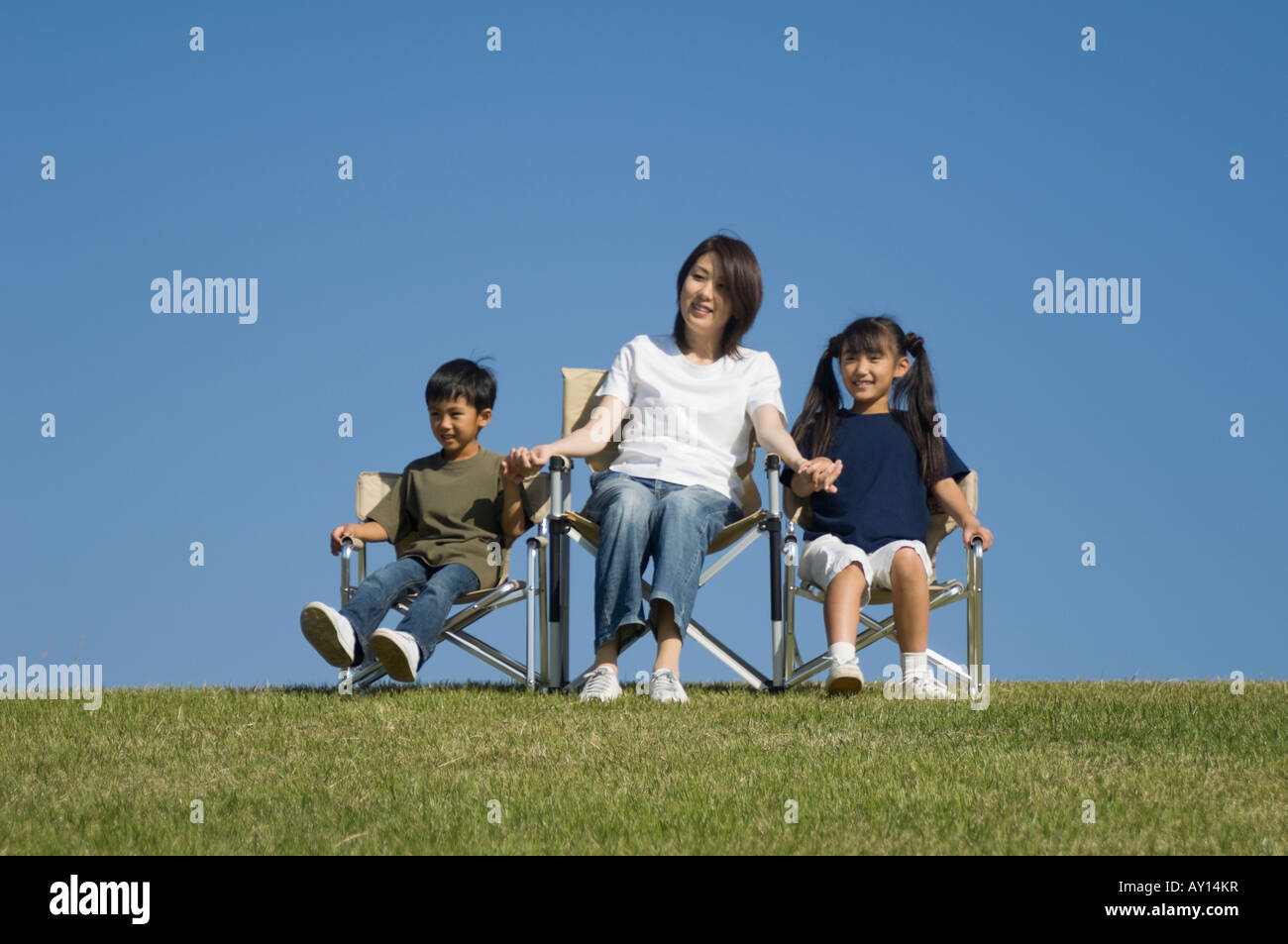 Mother and children sitting in chairs Stock Photo - Alamy