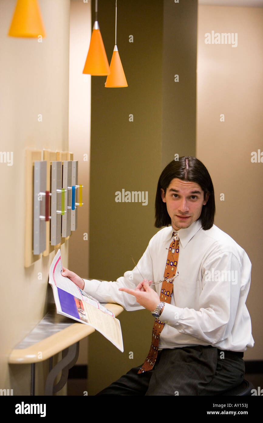 Portrait of a businessman pointing towards magazine in an office Stock ...