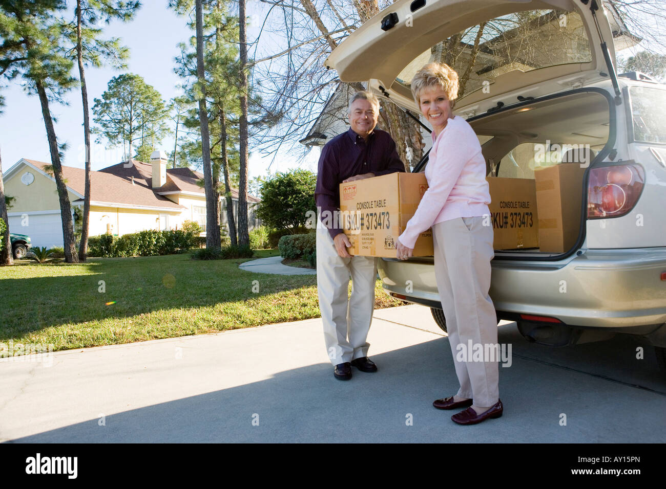 Portrait of a mature couple removing a cardboard box from a car Stock ...