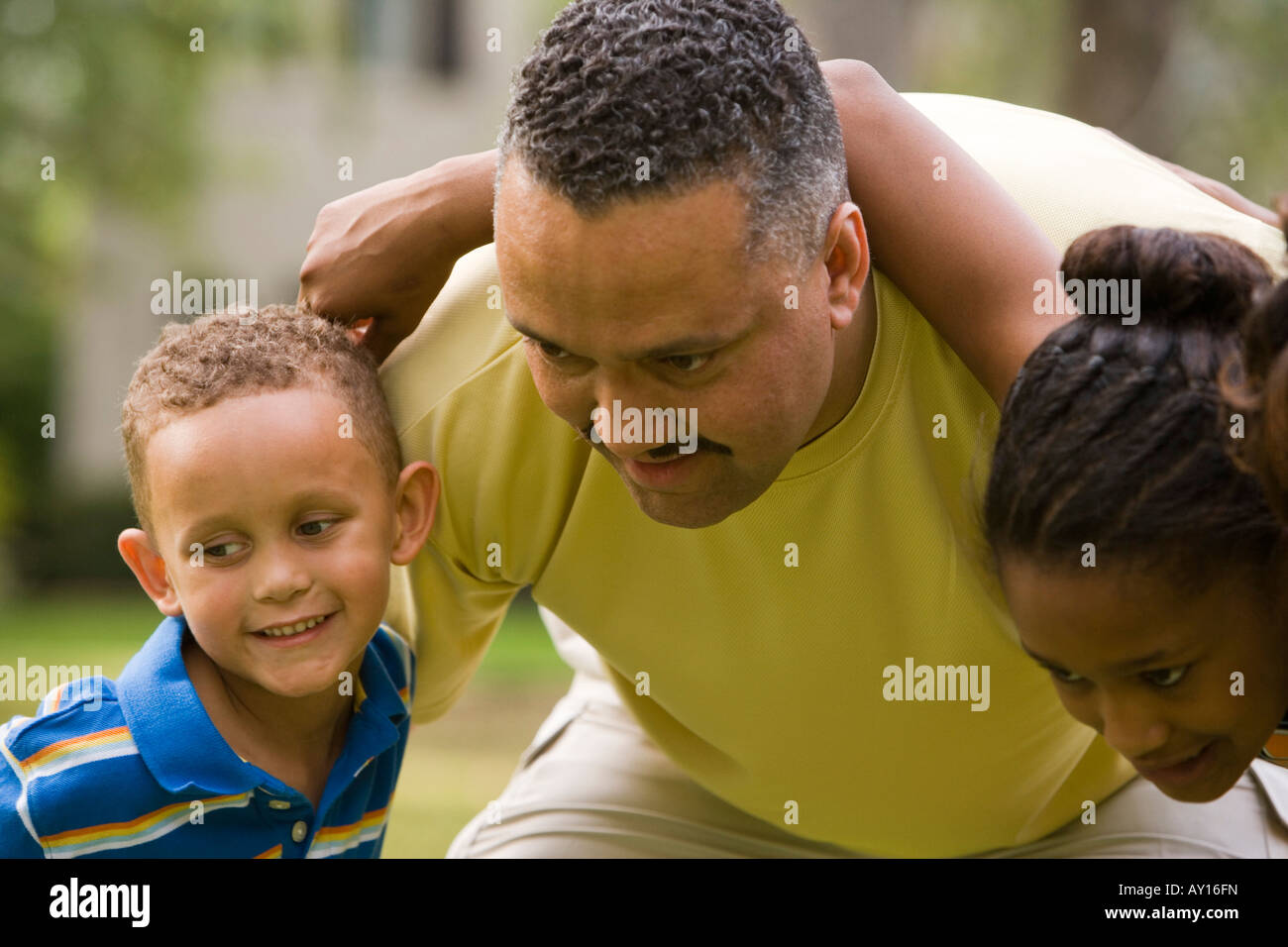 Parents standing with their son at park Stock Photo - Alamy