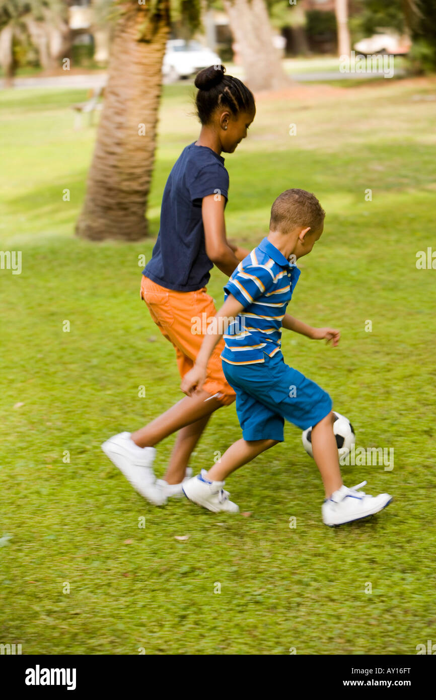Children playing soccer ball at park Stock Photo - Alamy