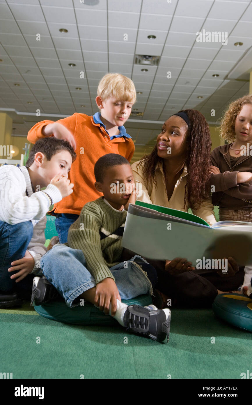 Teacher teaching students in the library Stock Photo - Alamy