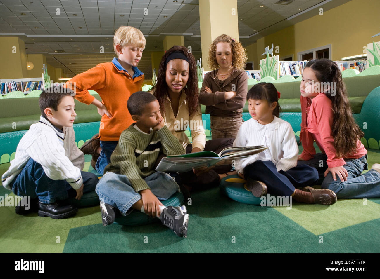 Teacher teaching students in the library Stock Photo - Alamy