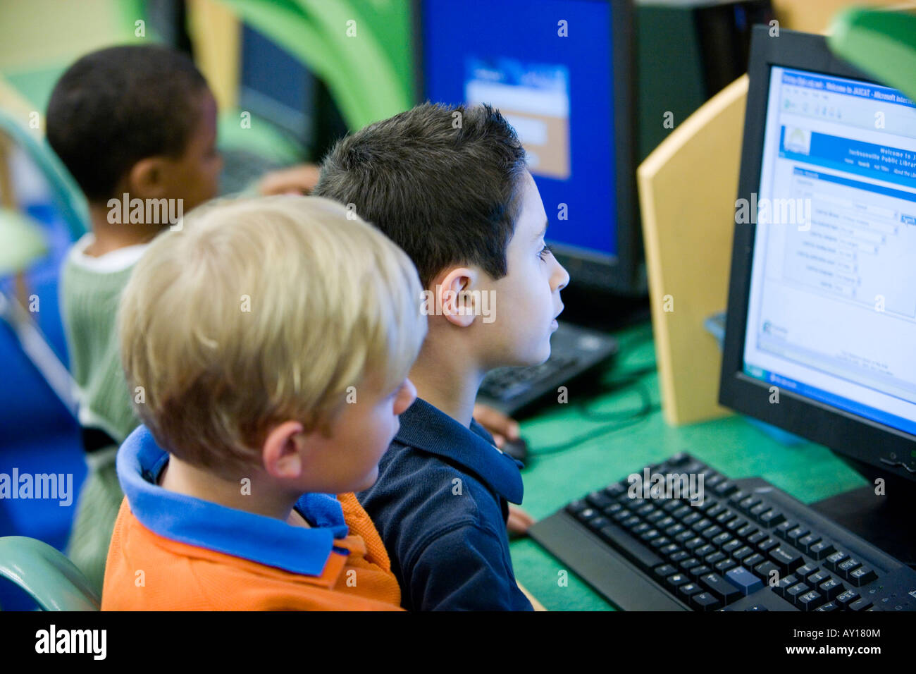 Schoolboys using computers in the library Stock Photo - Alamy