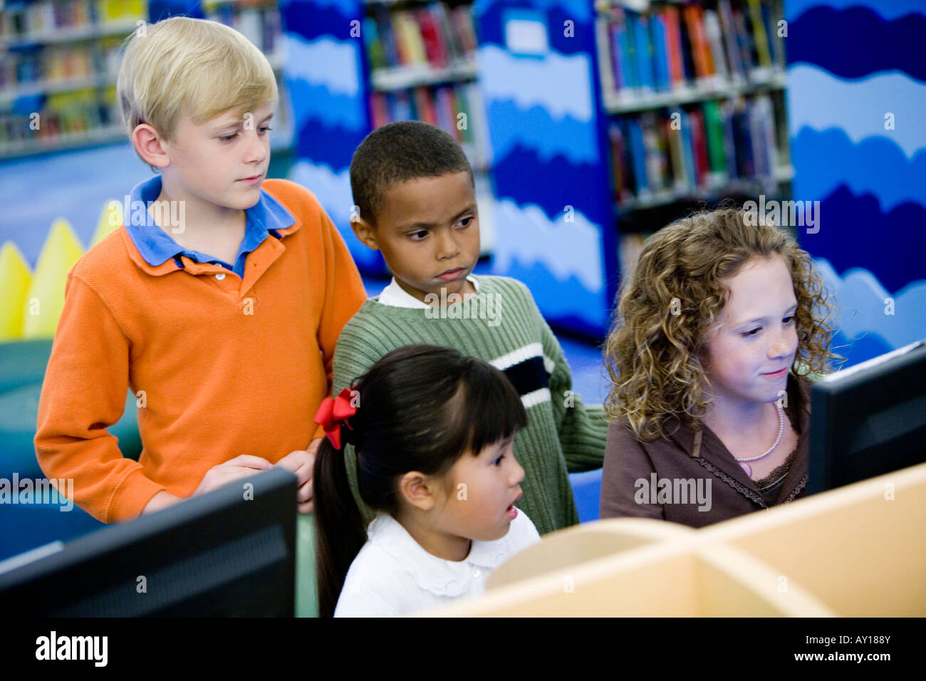 Schoolboys and girls using computer in the library Stock Photo - Alamy