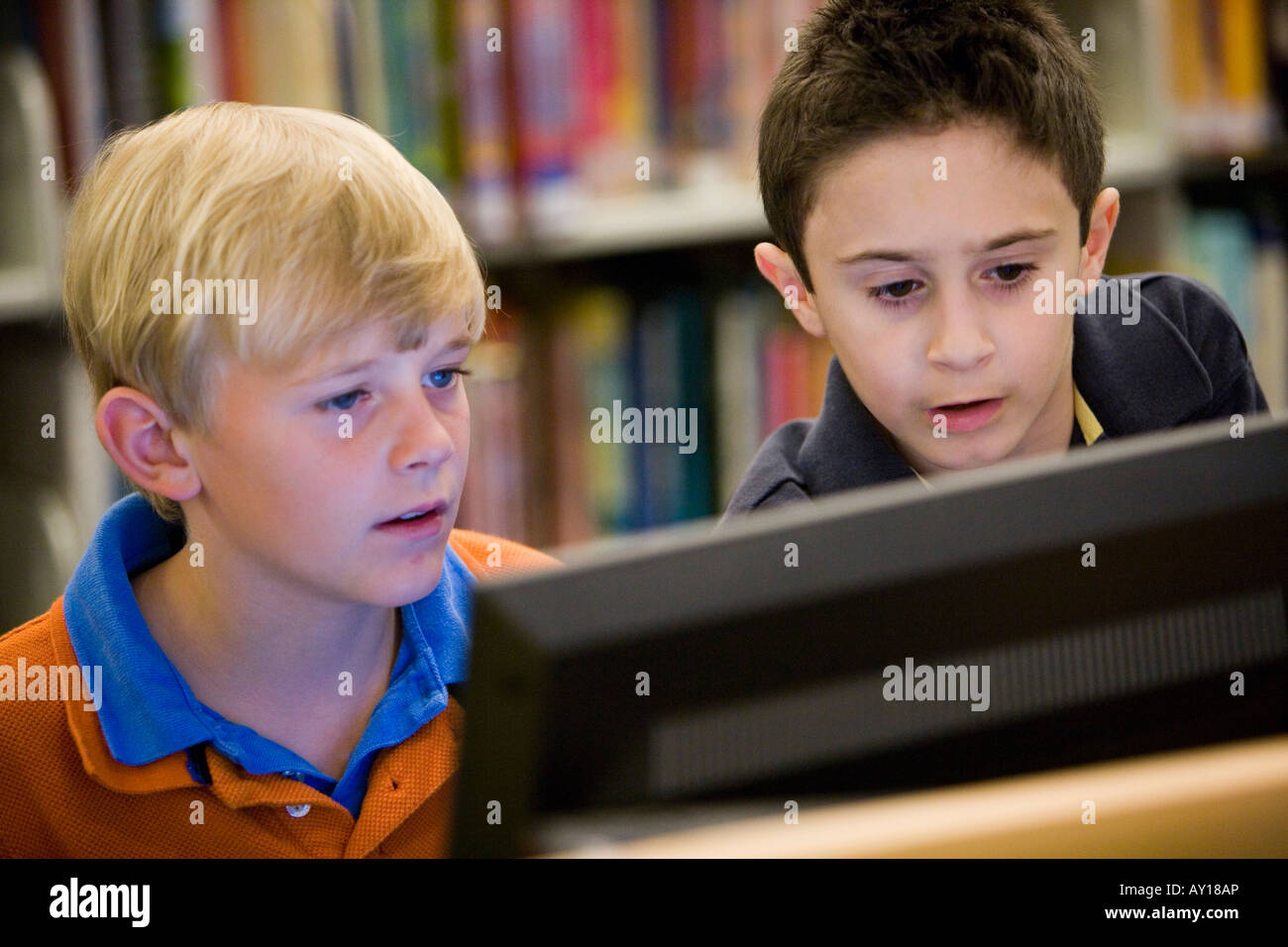 Students looking at a computer monitor in the library Stock Photo - Alamy