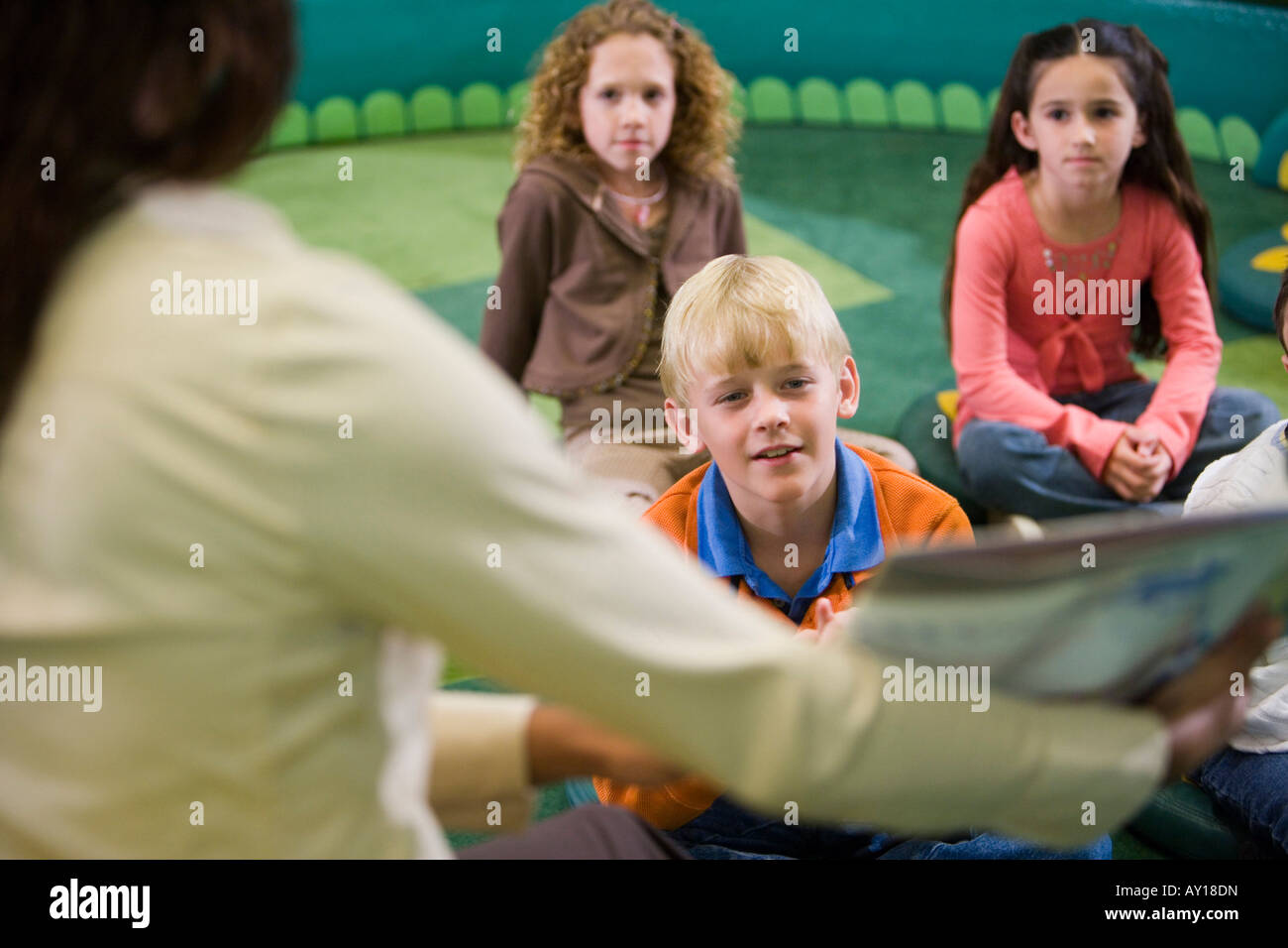 Teacher showing book to students in the library Stock Photo - Alamy