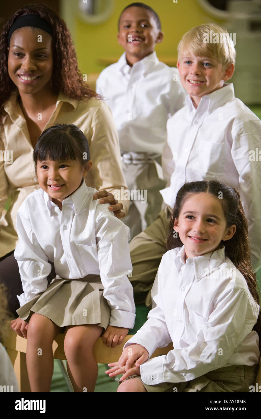 Cheerful teacher sitting with students Stock Photo - Alamy