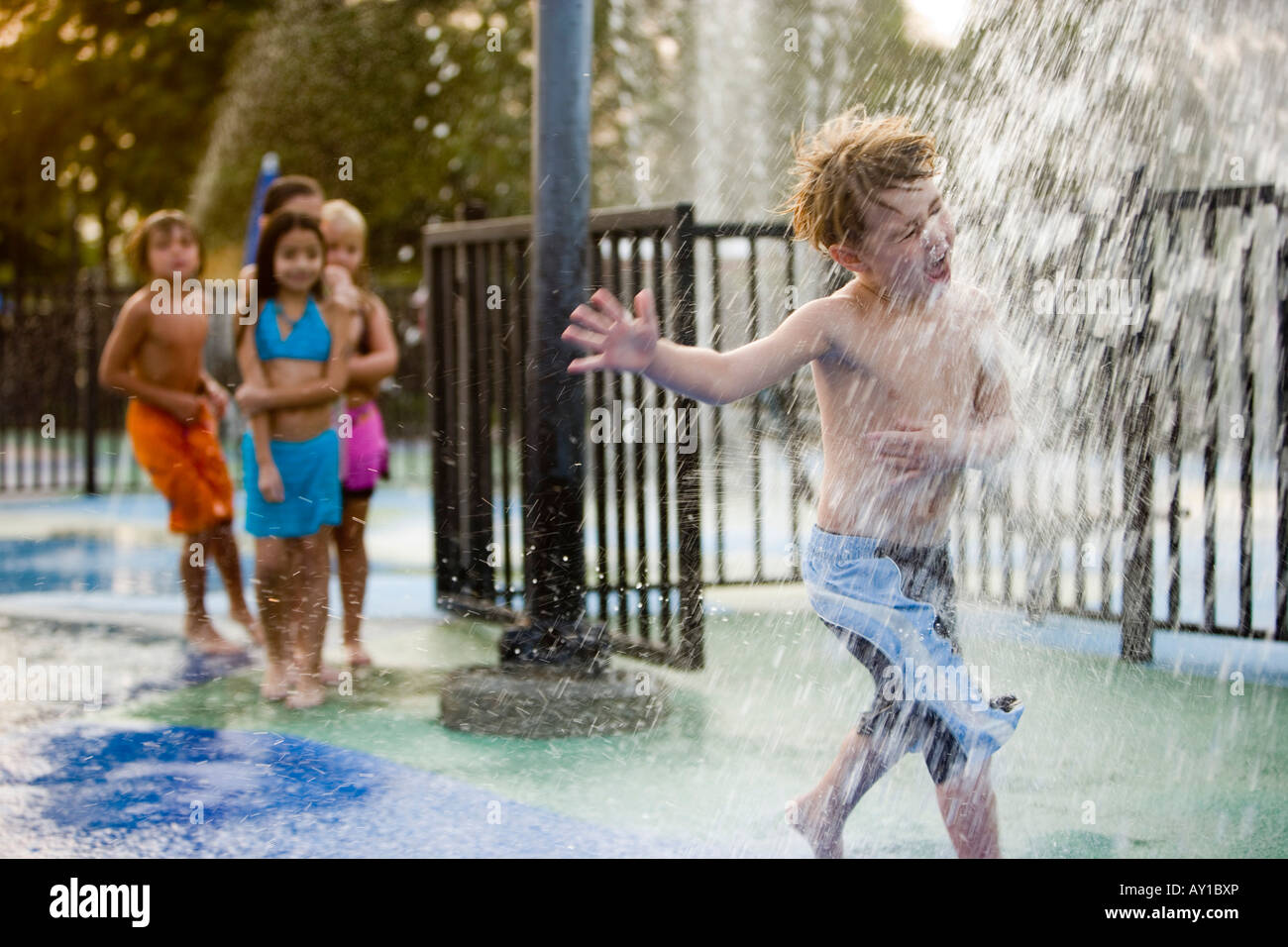 Boy standing under a shower Stock Photo - Alamy