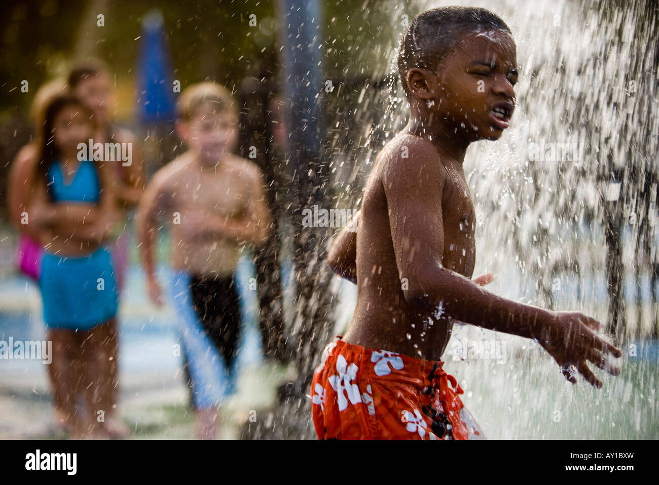 Boy standing under a shower Stock Photo - Alamy
