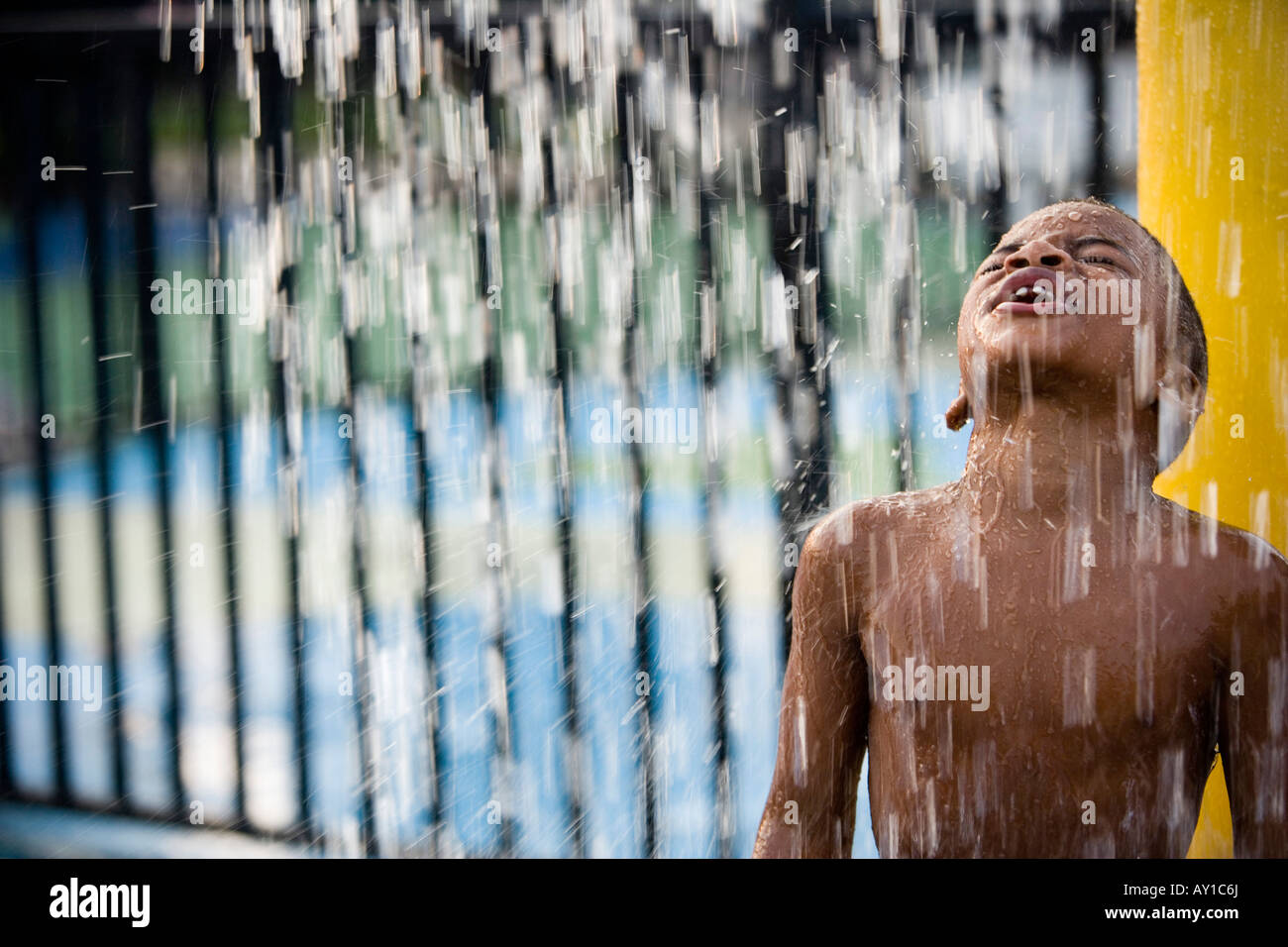 Boy standing under a shower Stock Photo - Alamy