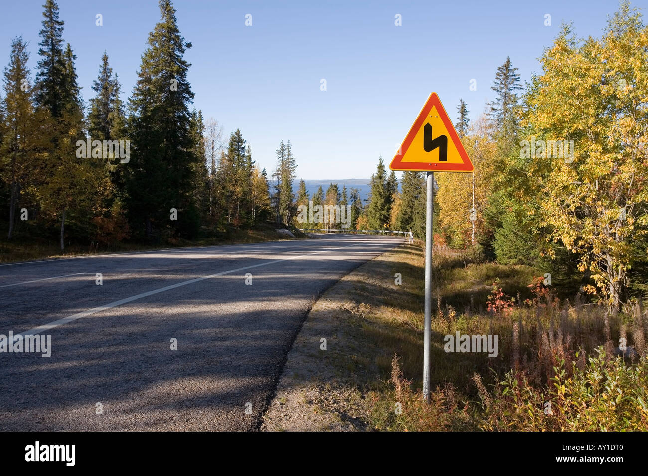 Several bends, the first to the left traffic sign Stock Photo - Alamy