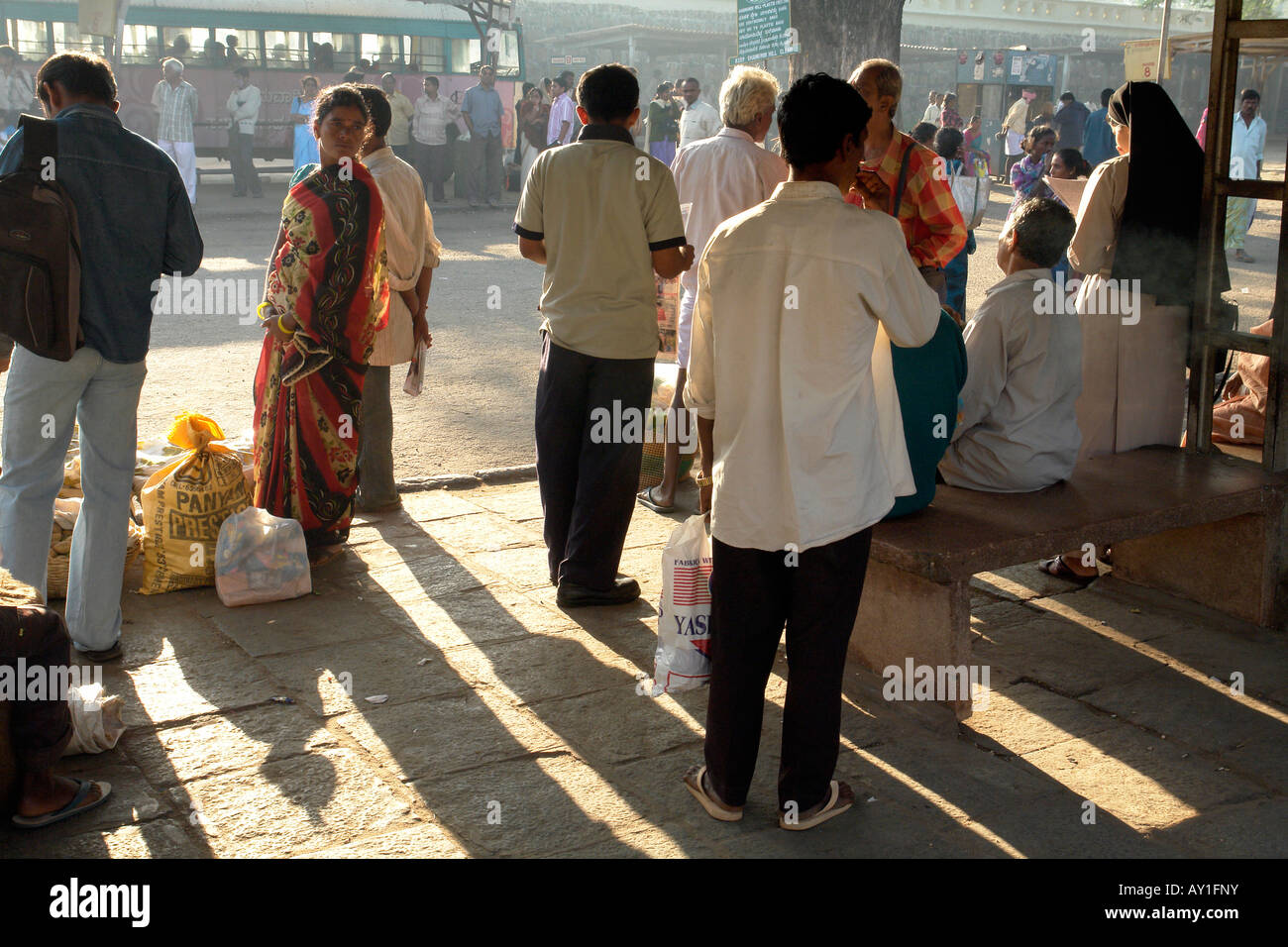 indian passengers waiting at the bus station in mysore by morning light ...