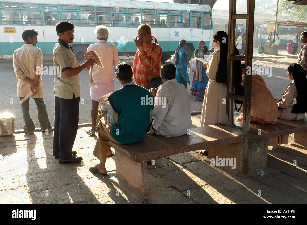 indian passengers waiting at the bus station in mysore by early morning ...