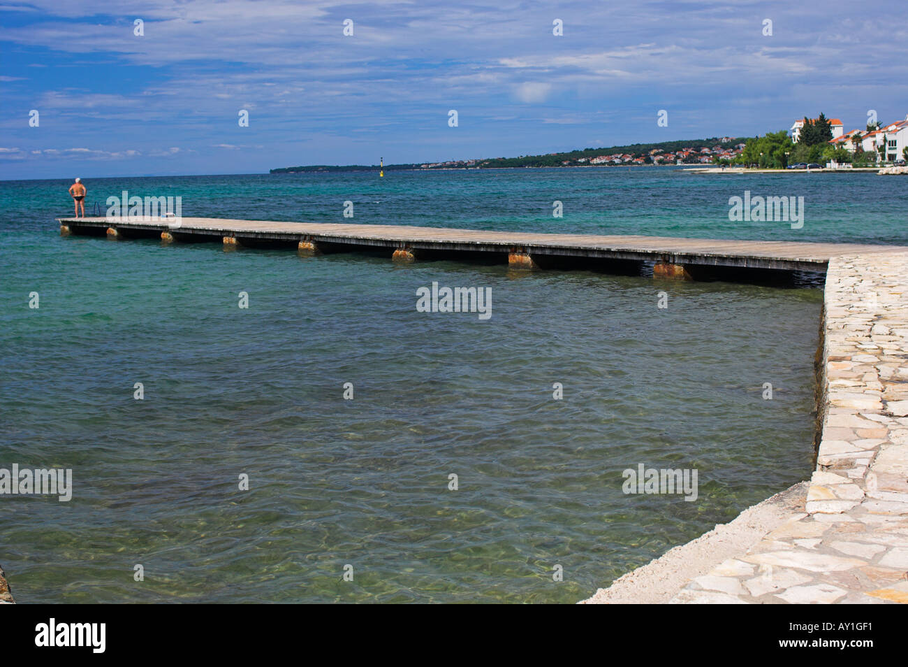 Man standing on end of pier looking out to sea Stock Photo - Alamy