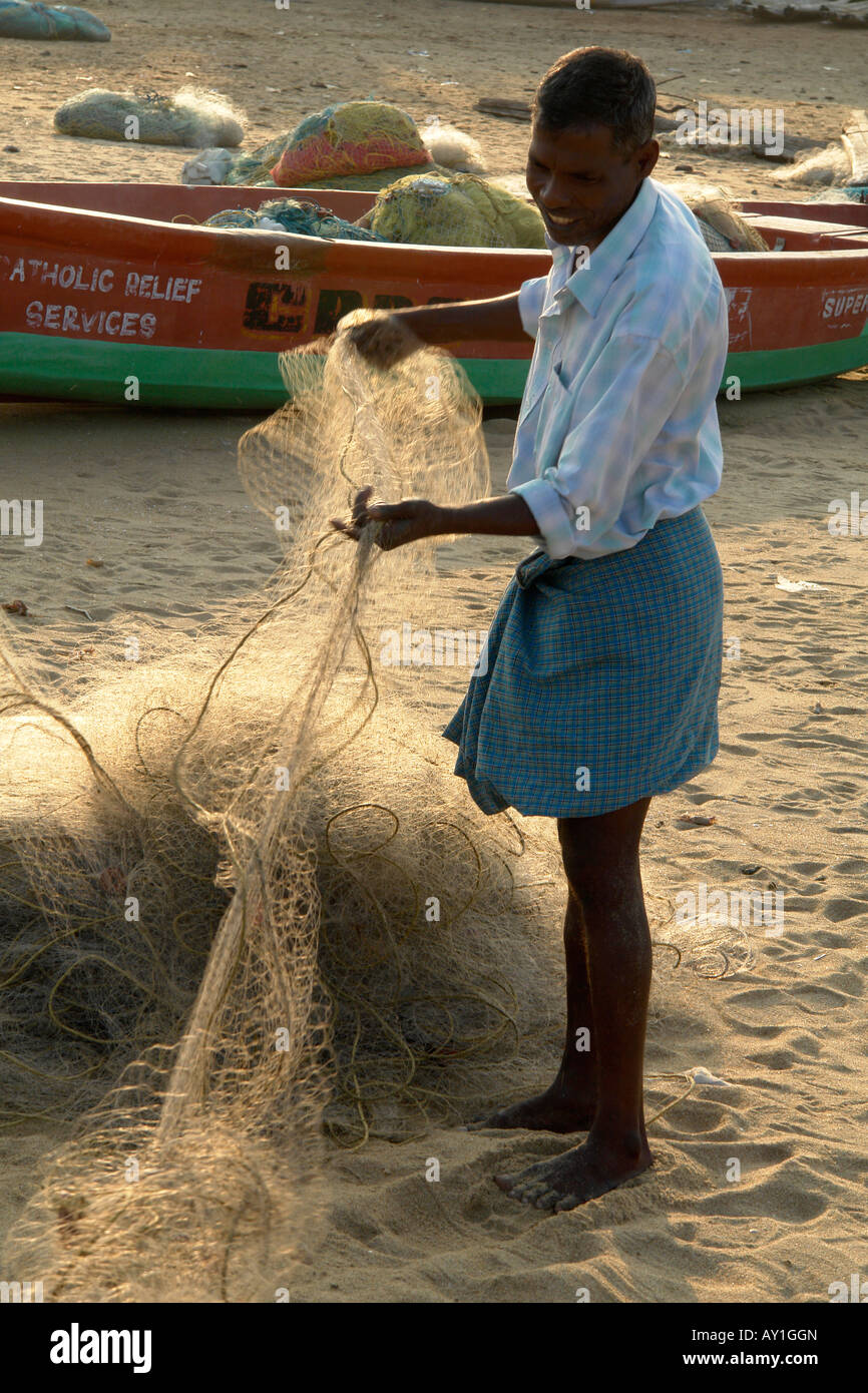 indian fisherman checking his fishing nets on the beach at mamallapuram ...