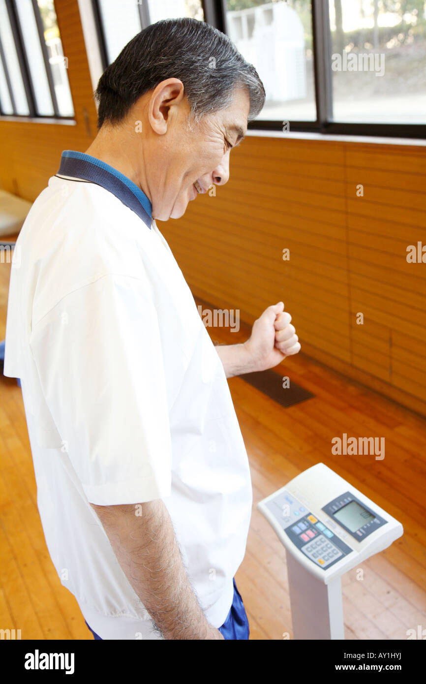 Old man weighing hisself Stock Photo - Alamy