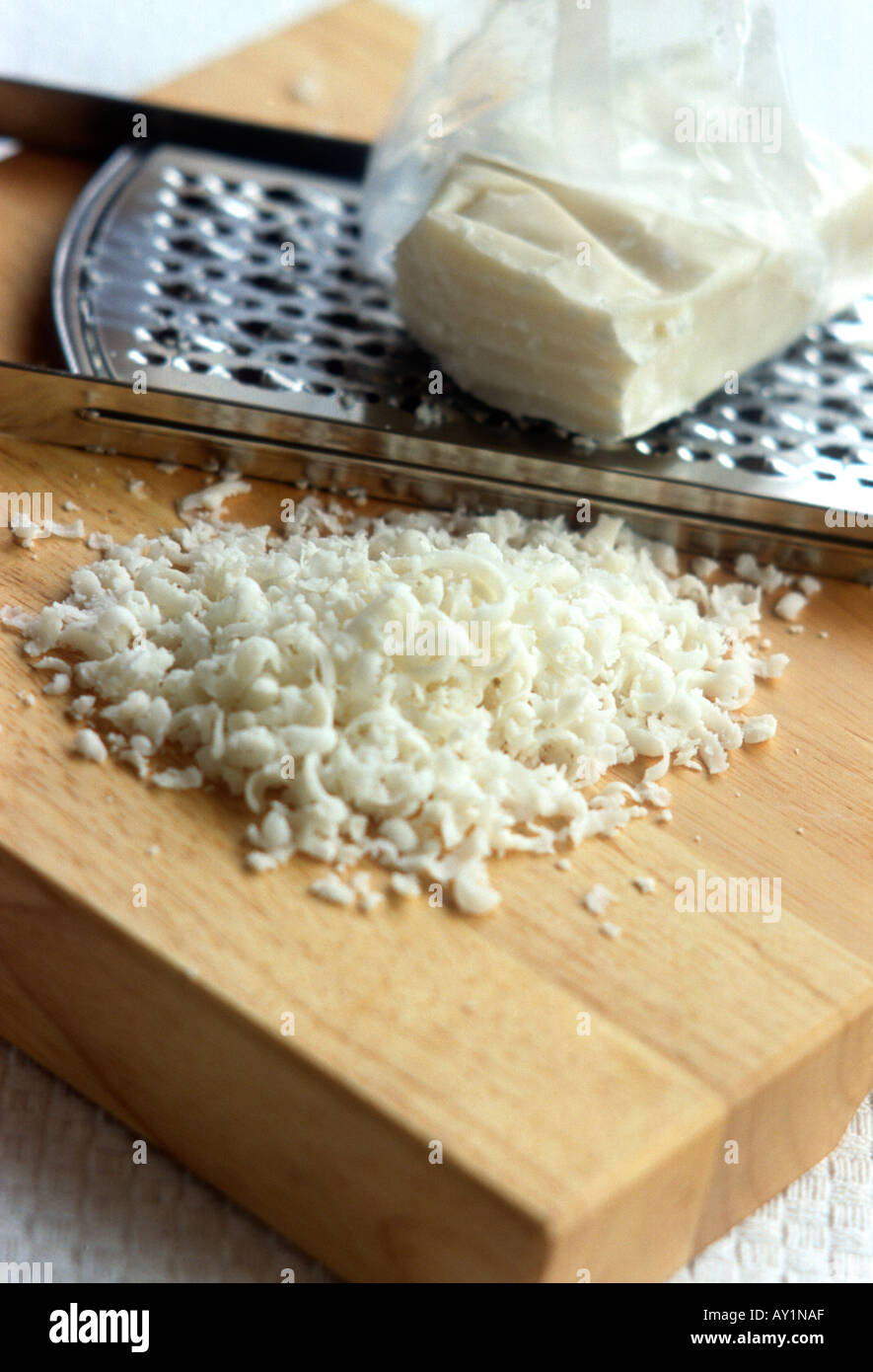 Block of creamed coconut being grated Stock Photo - Alamy