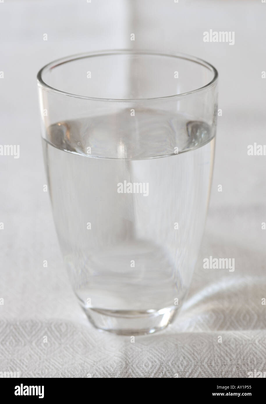 Simple handblown glass of plain water on creamy white linen cloth Stock ...