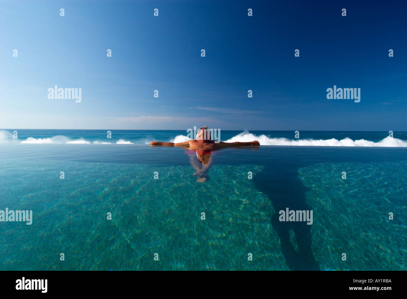 Man relaxing in infinity pool hi-res stock photography and images - Alamy