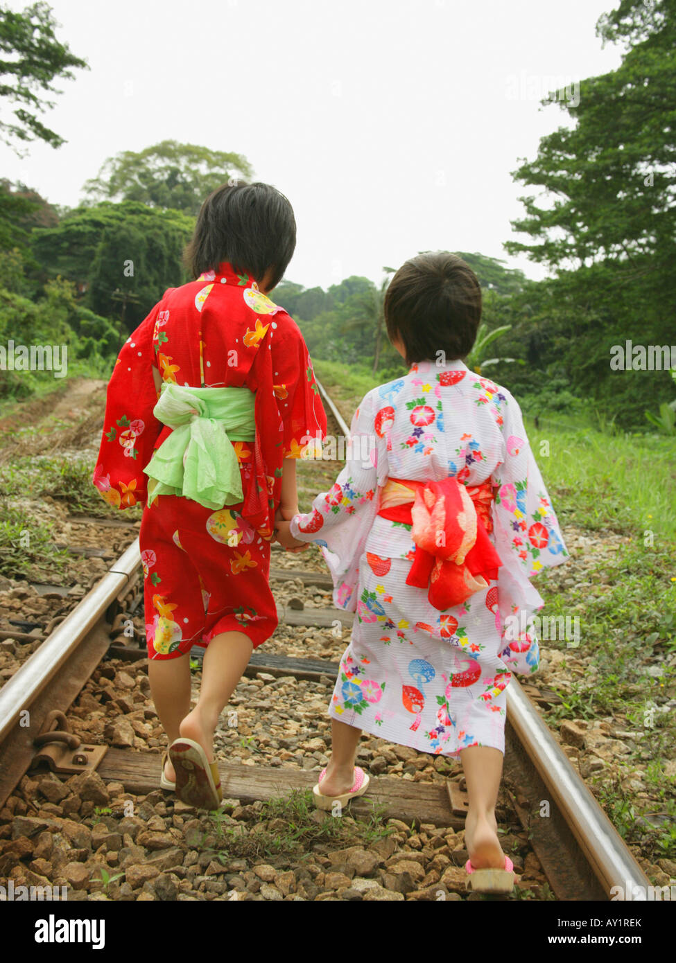 Rear view of two girls walking on railroad tracks Stock Photo - Alamy