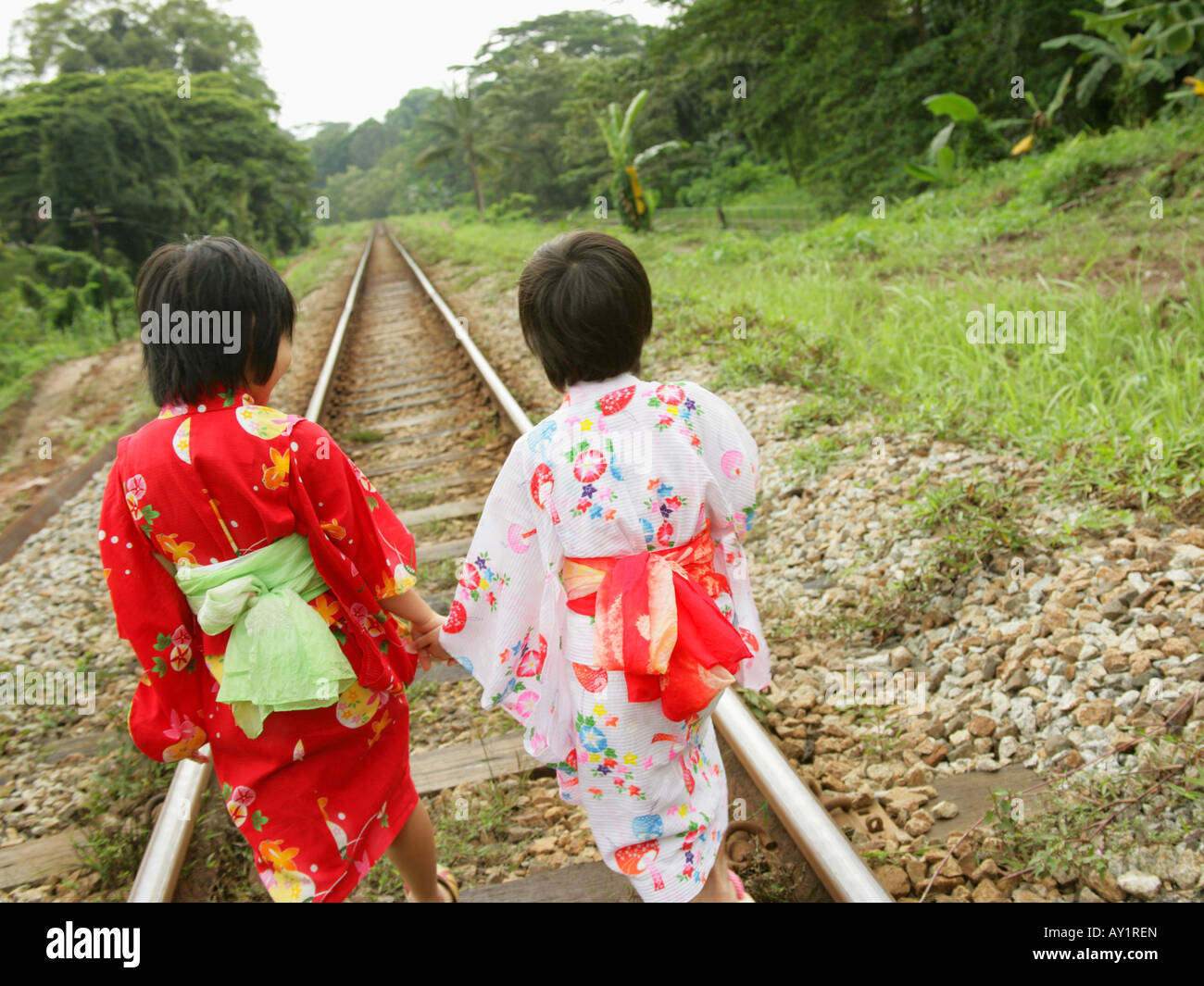 Rear view of two girls walking on railroad tracks Stock Photo - Alamy