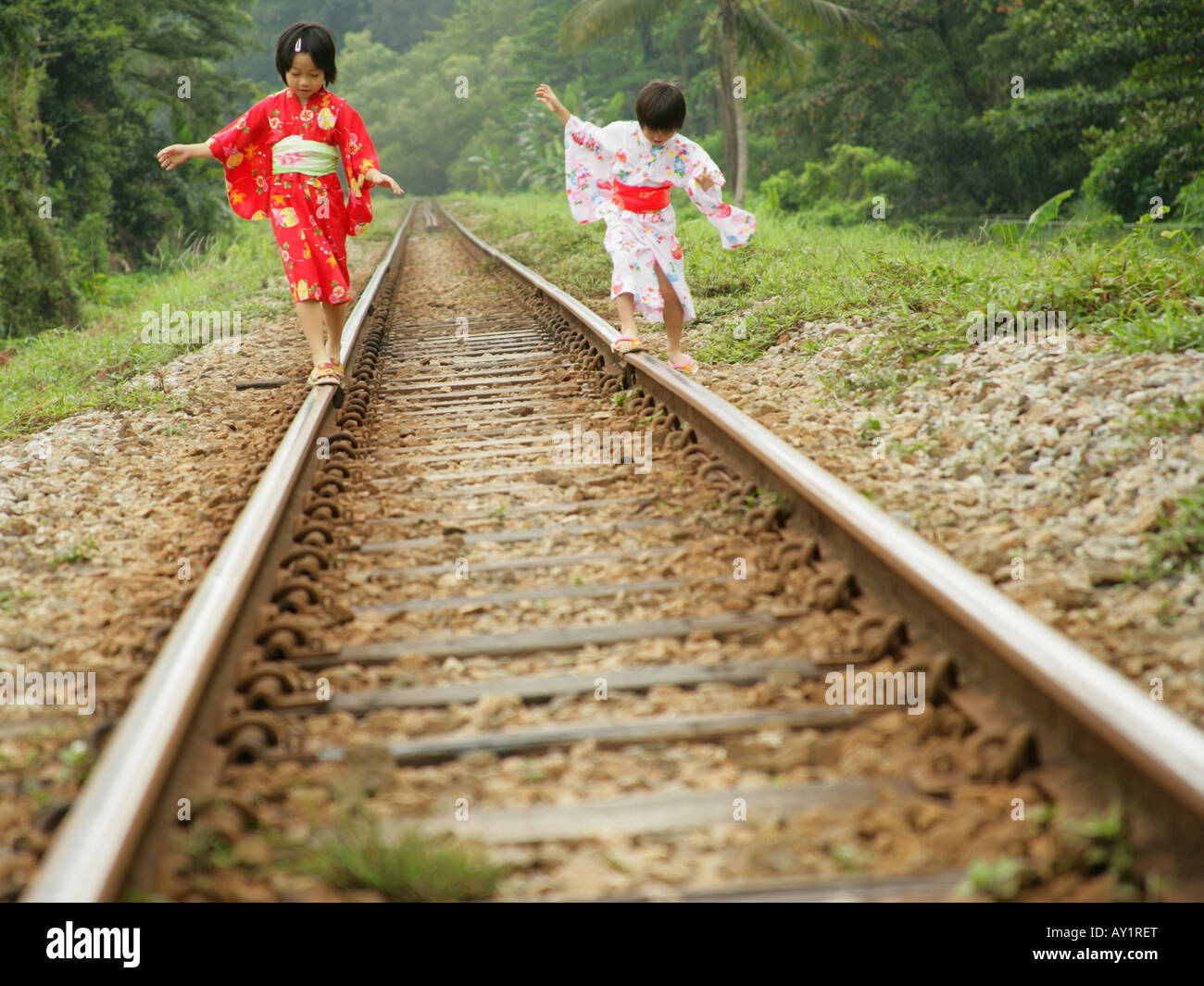 Two girls walking on railroad tracks Stock Photo - Alamy