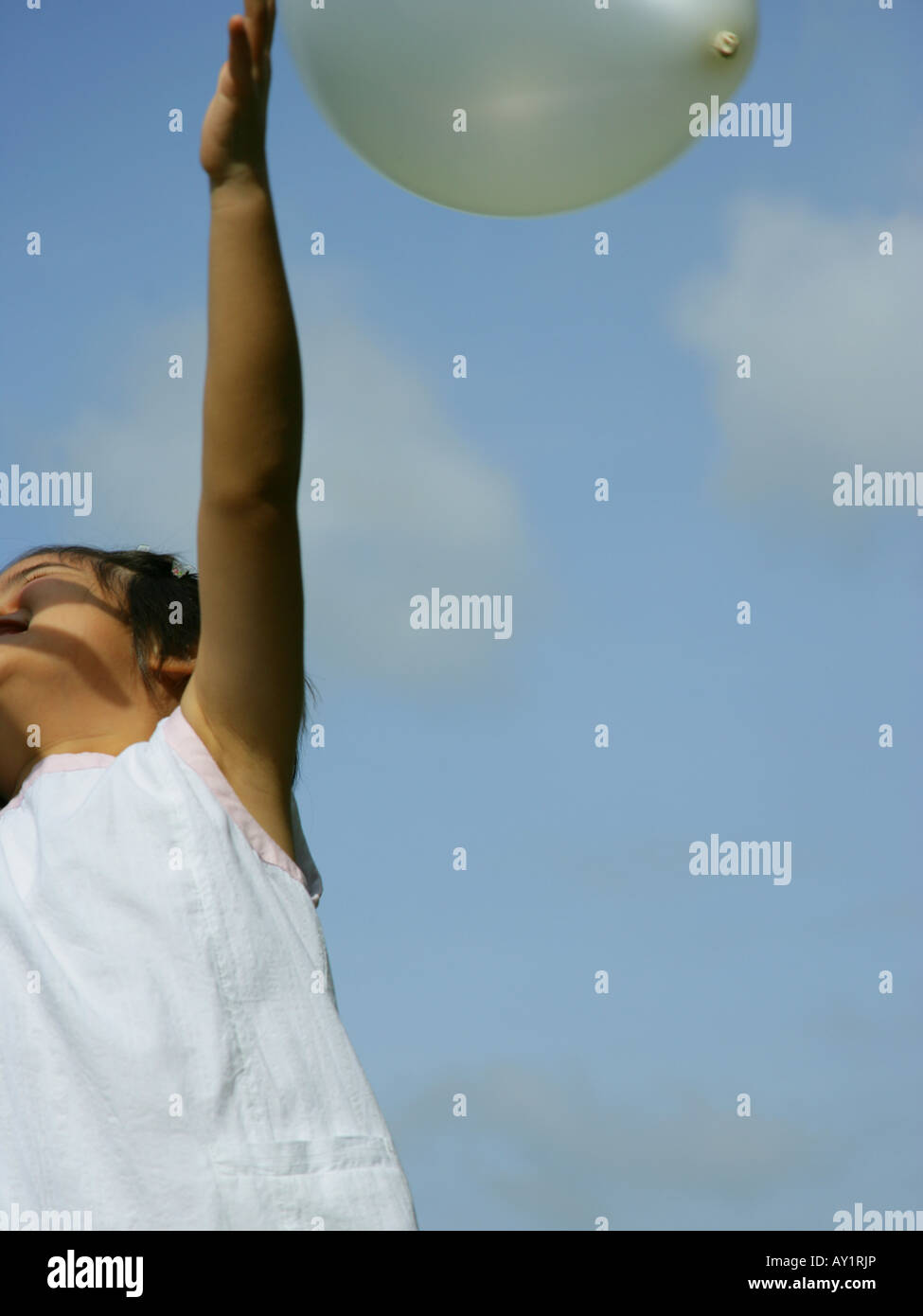 Low angle view of a girl reaching for a balloon Stock Photo - Alamy