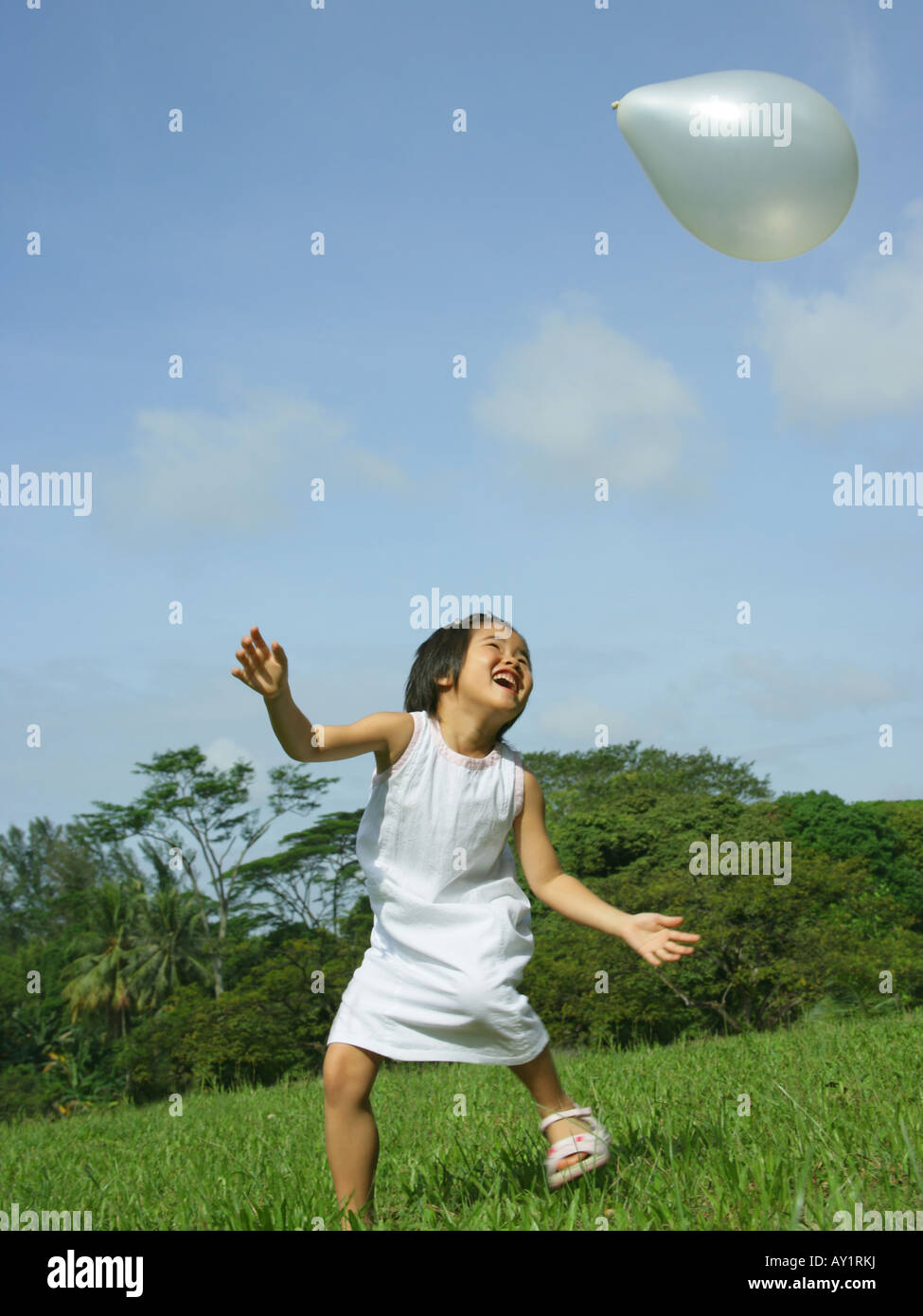 Girl reaching for a balloon Stock Photo - Alamy
