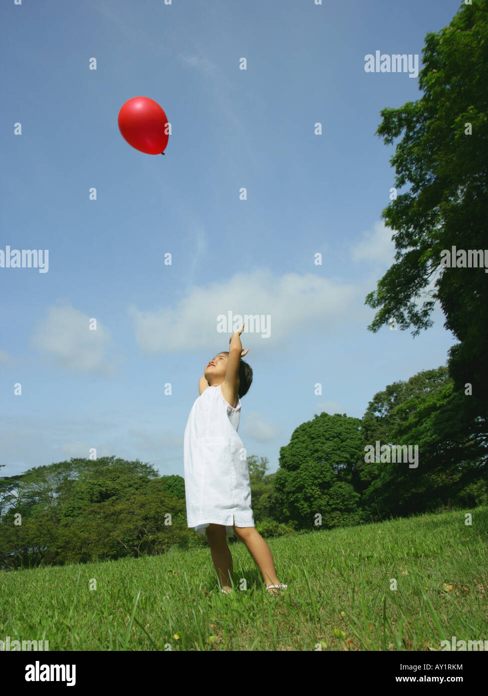 Low angle view of a girl catching a balloon Stock Photo - Alamy