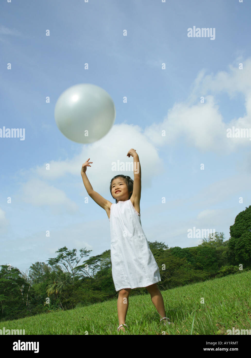 Low angle view of a girl catching a balloon Stock Photo - Alamy