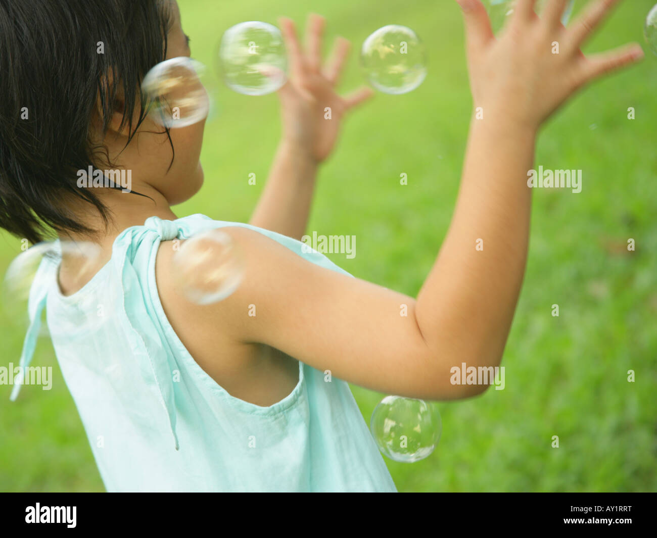 Close-up of a girl catching bubbles Stock Photo - Alamy
