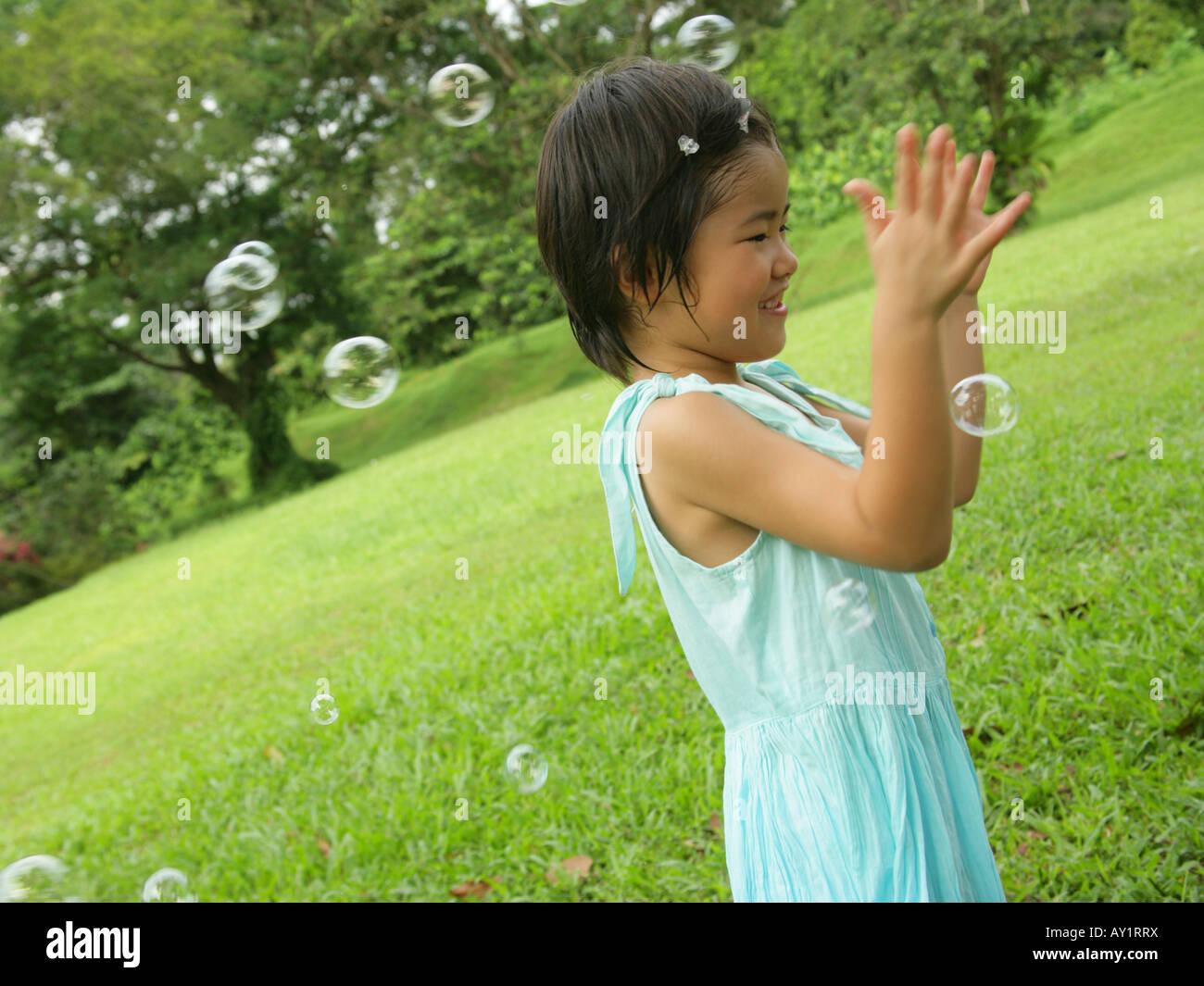 Side profile of a girl catching bubbles Stock Photo - Alamy